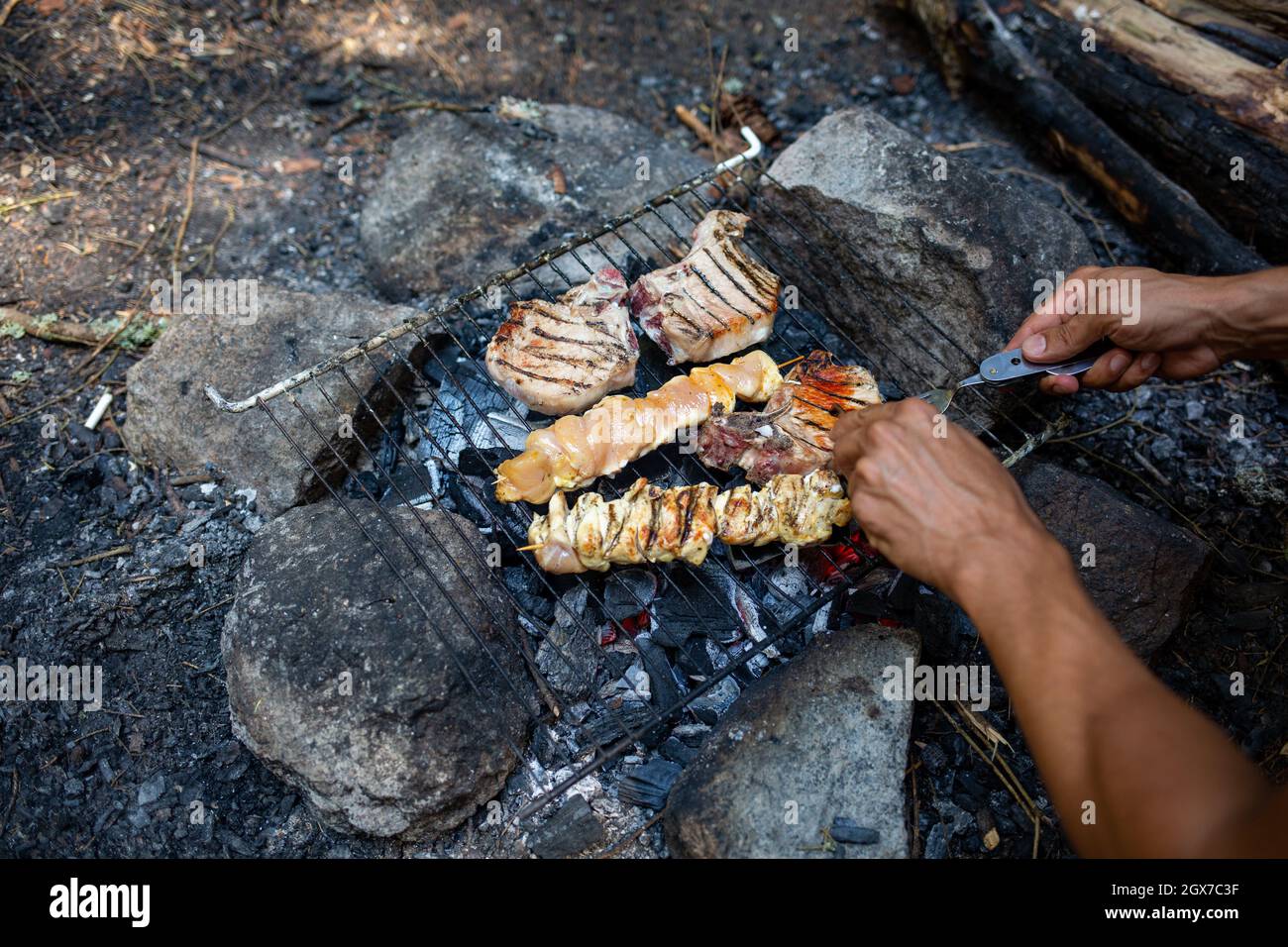 Top view of man's hands cooking juicy meat on a grill Stock Photo - Alamy