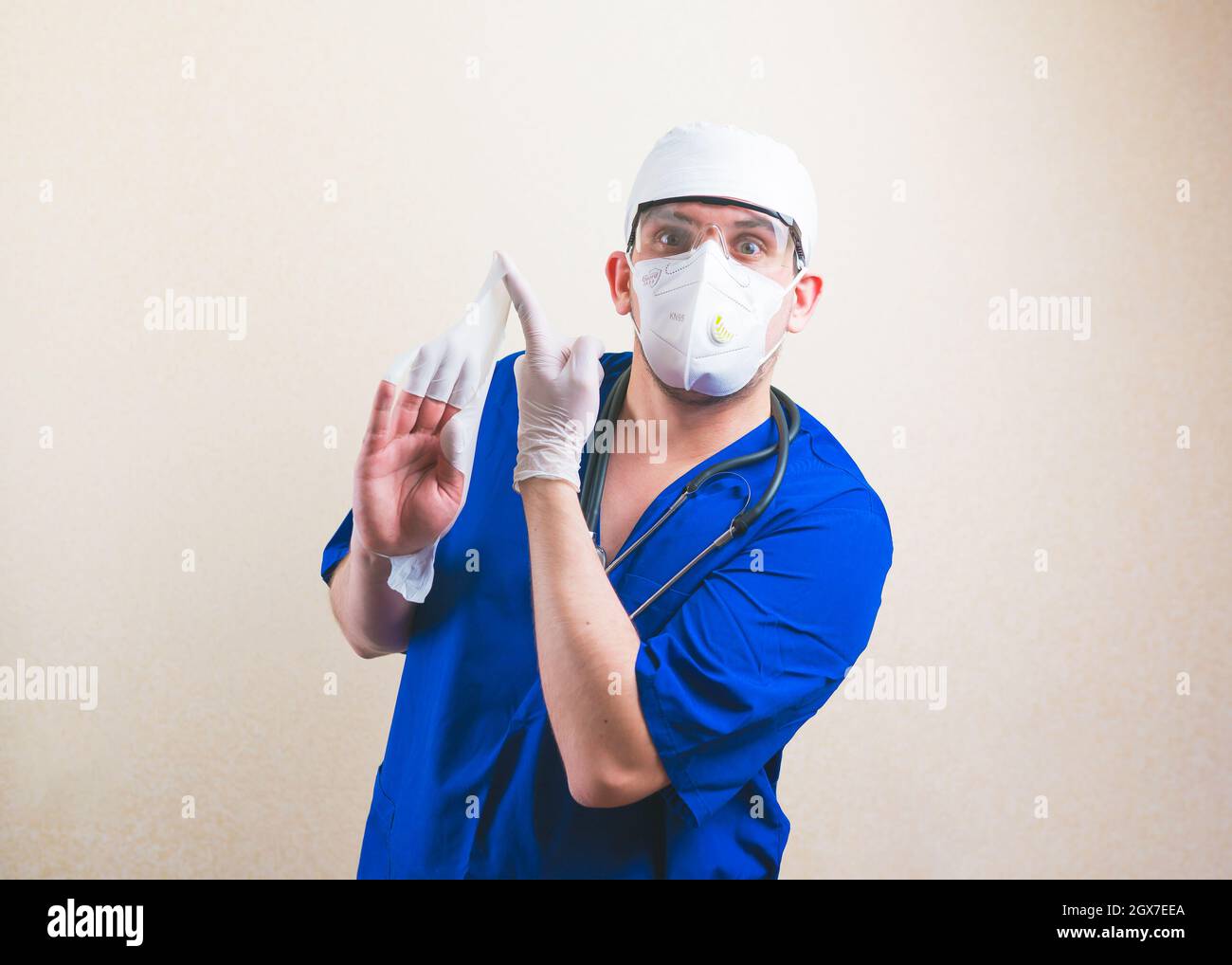 Doctor with white glowes on hands in blue surgeon suit and protective ...