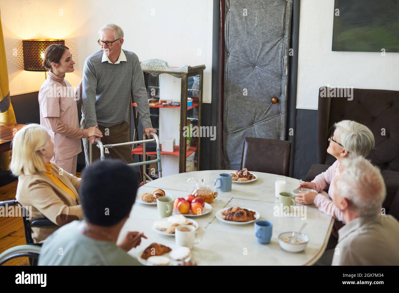 Wide angle view at diverse group of senior people enjoying breakfast at ...
