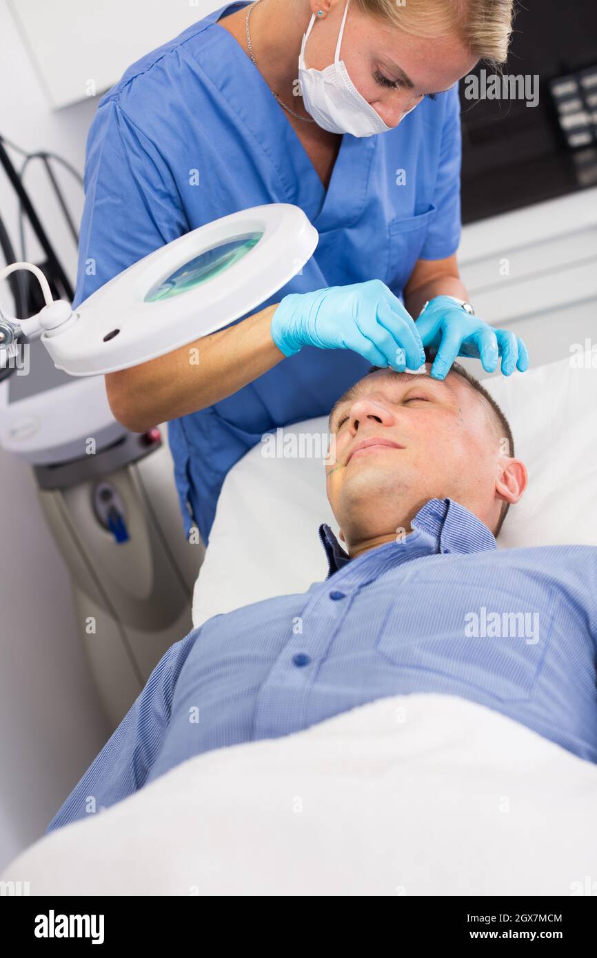 Female doctor is doing cleaning skin procedure to client Stock Photo ...