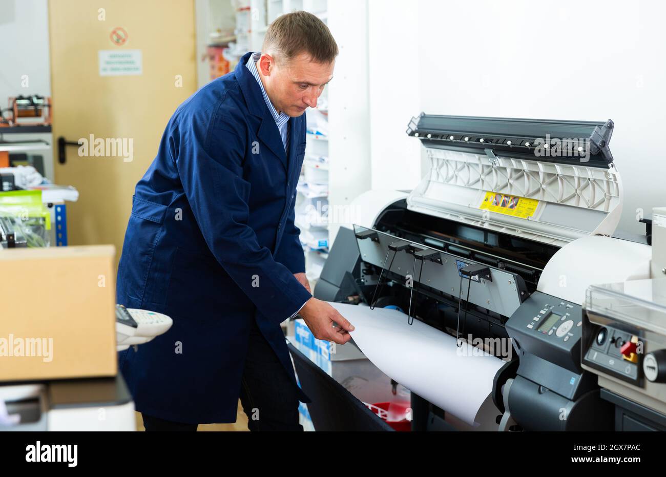 Repairman changes paper roll in plotter Stock Photo - Alamy