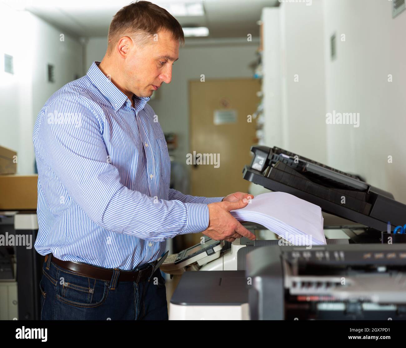 Office worker puts a stack of paper in the printer Stock Photo - Alamy