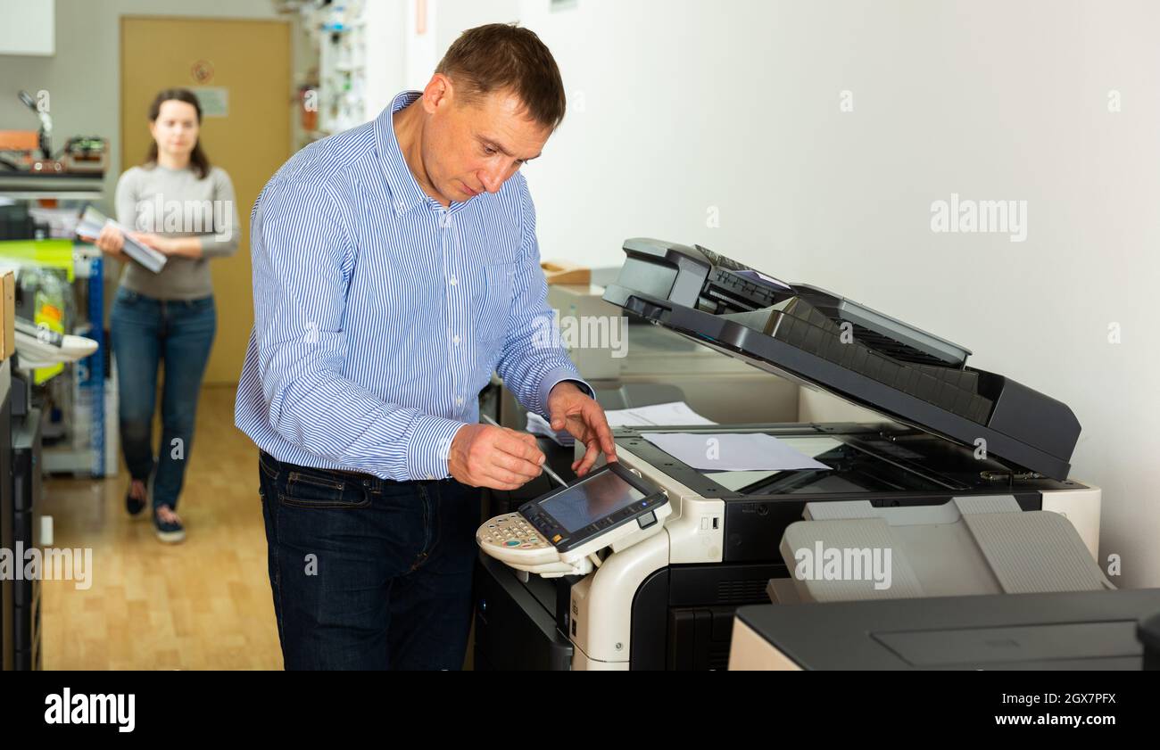 Worker is printing a file, document in the office room Stock Photo - Alamy