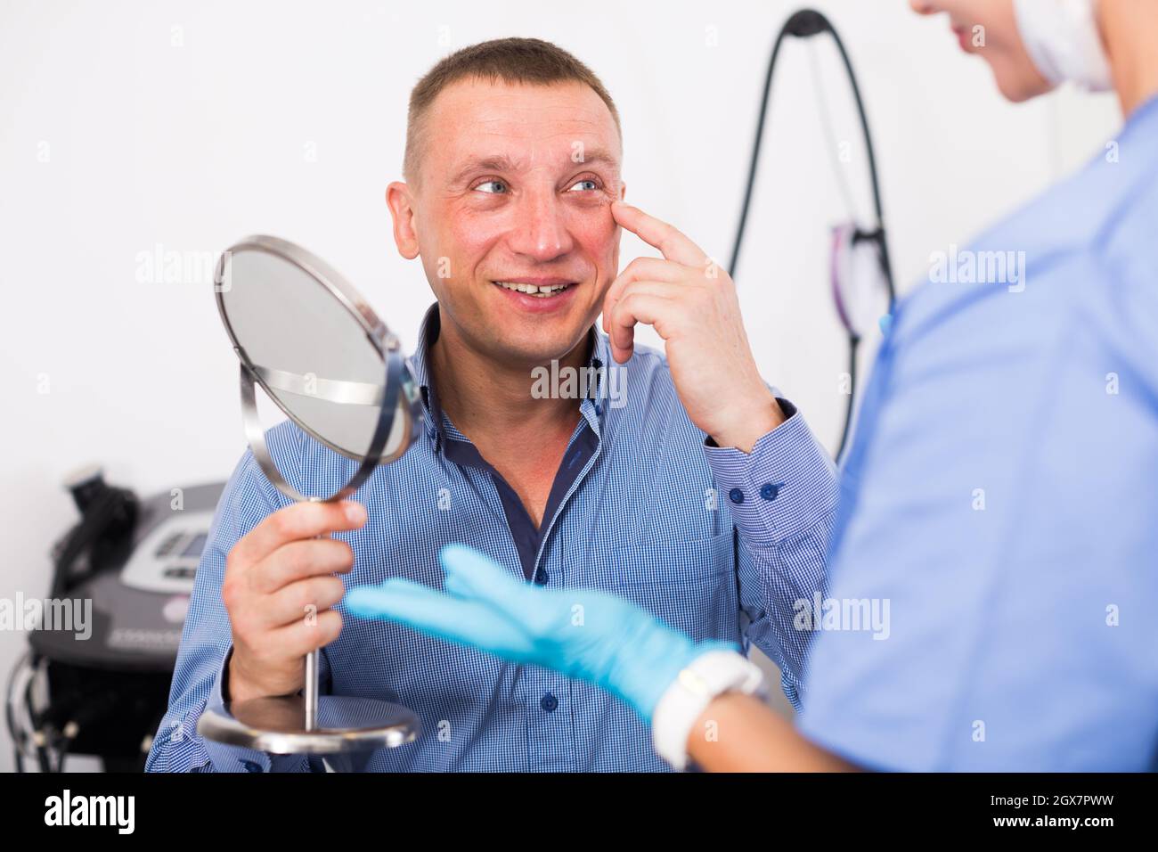 Woman doctor is examining patient behind mirror before the procedure ...