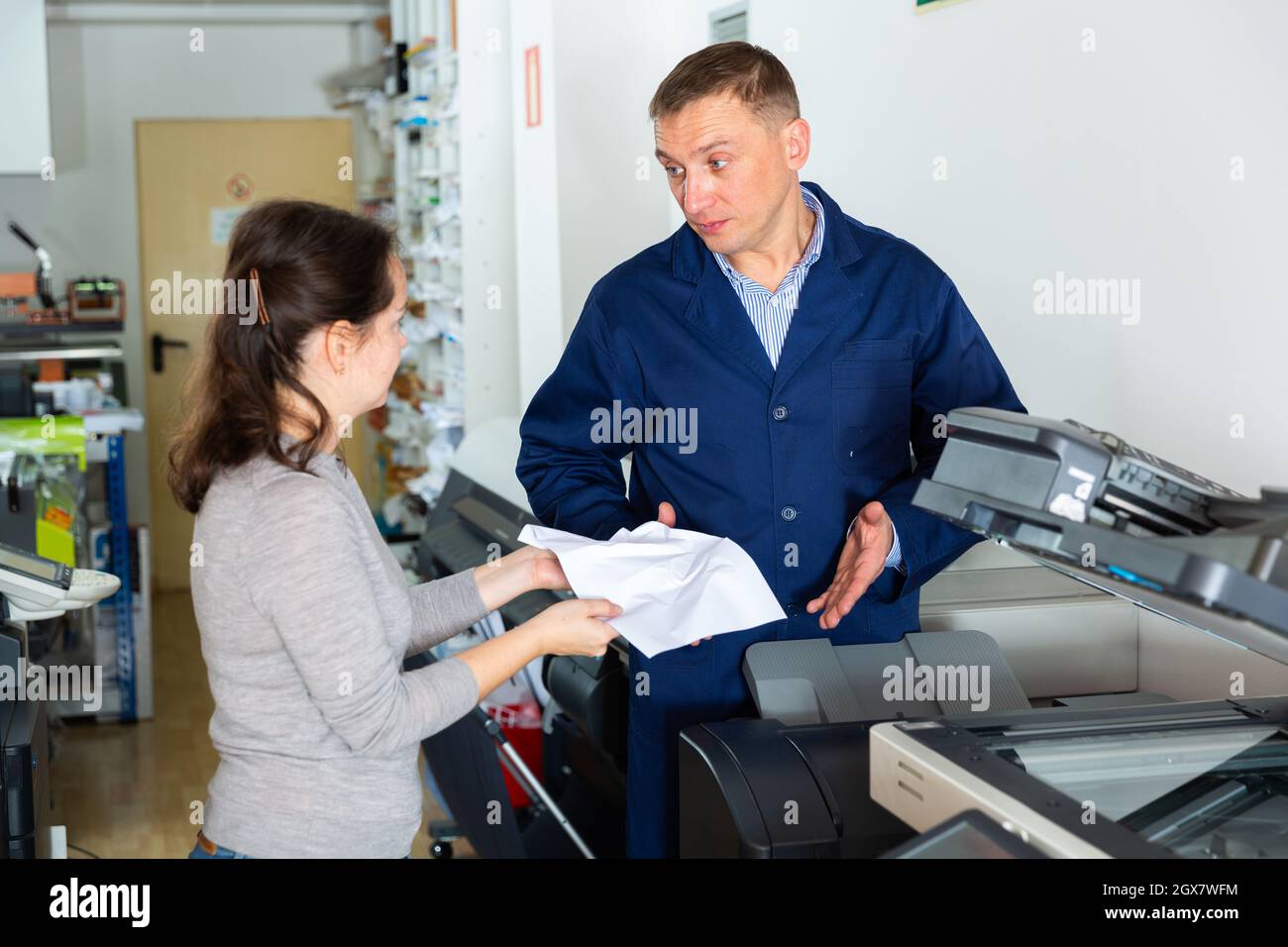Office employee complains to repairman about poor printer Stock Photo ...