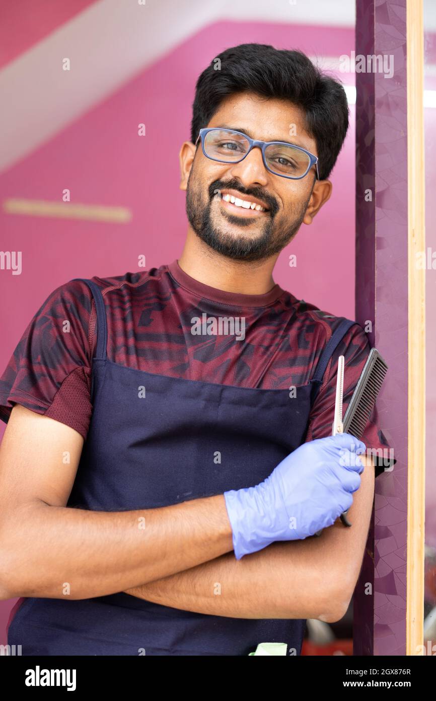 happy smiling barber at saloon confidently looking at camera in front ...