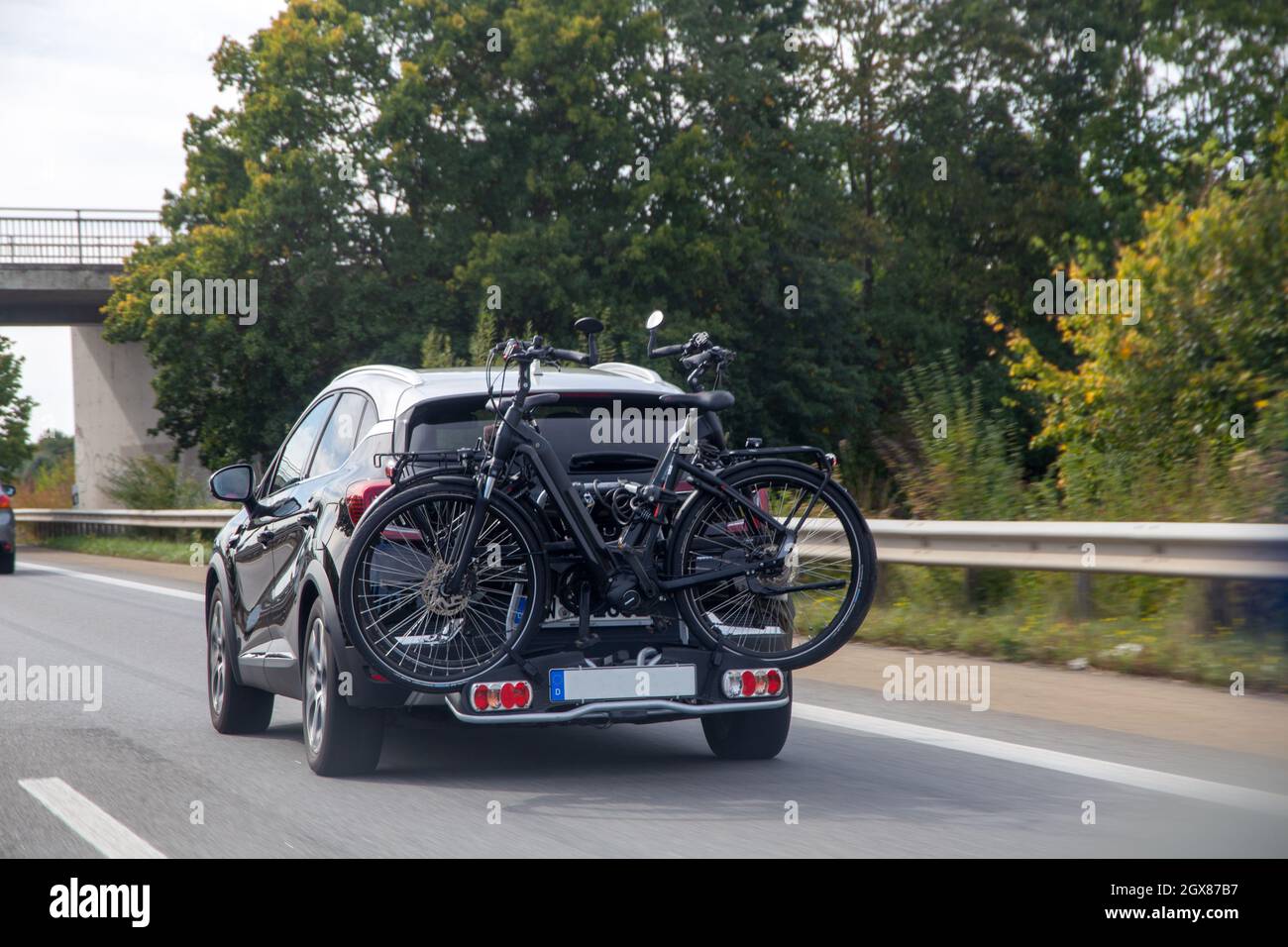 Car on the motorway transporting bicycles on the rear carrier Stock ...