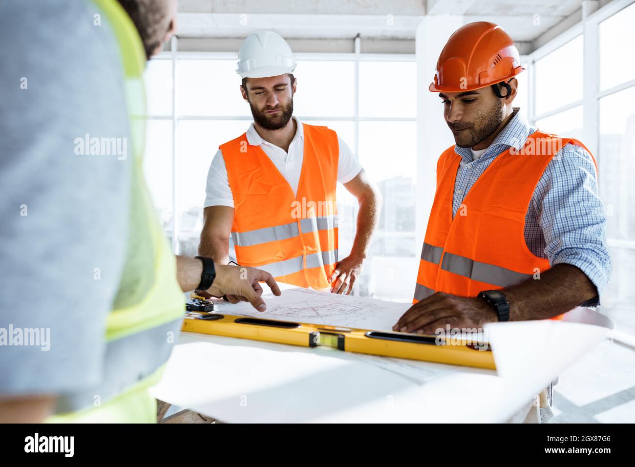 Two engineers man looking at project plan on the table in construction ...