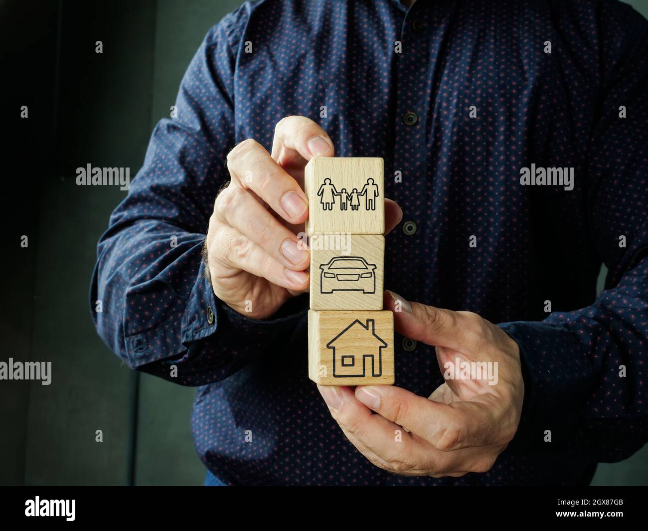 Comprehensive insurance coverage. Man holds cubes with home, car and ...