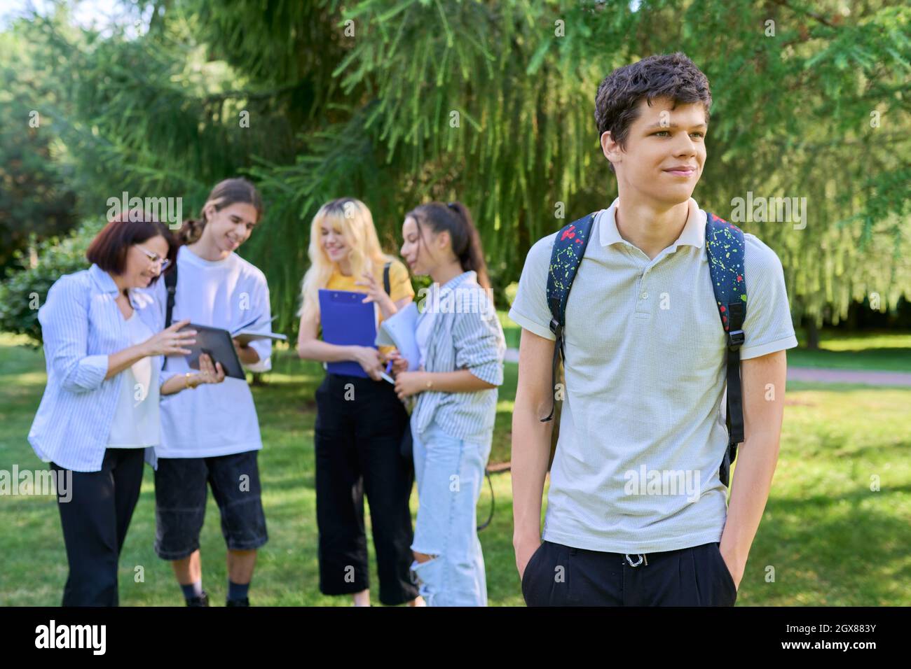 Portrait of male student in park campus, group of teenagers with ...
