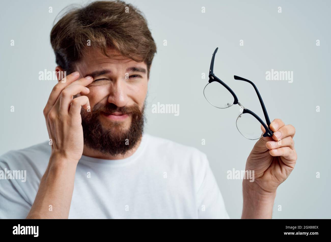 sick man with glasses in hand vision problems light background Stock ...