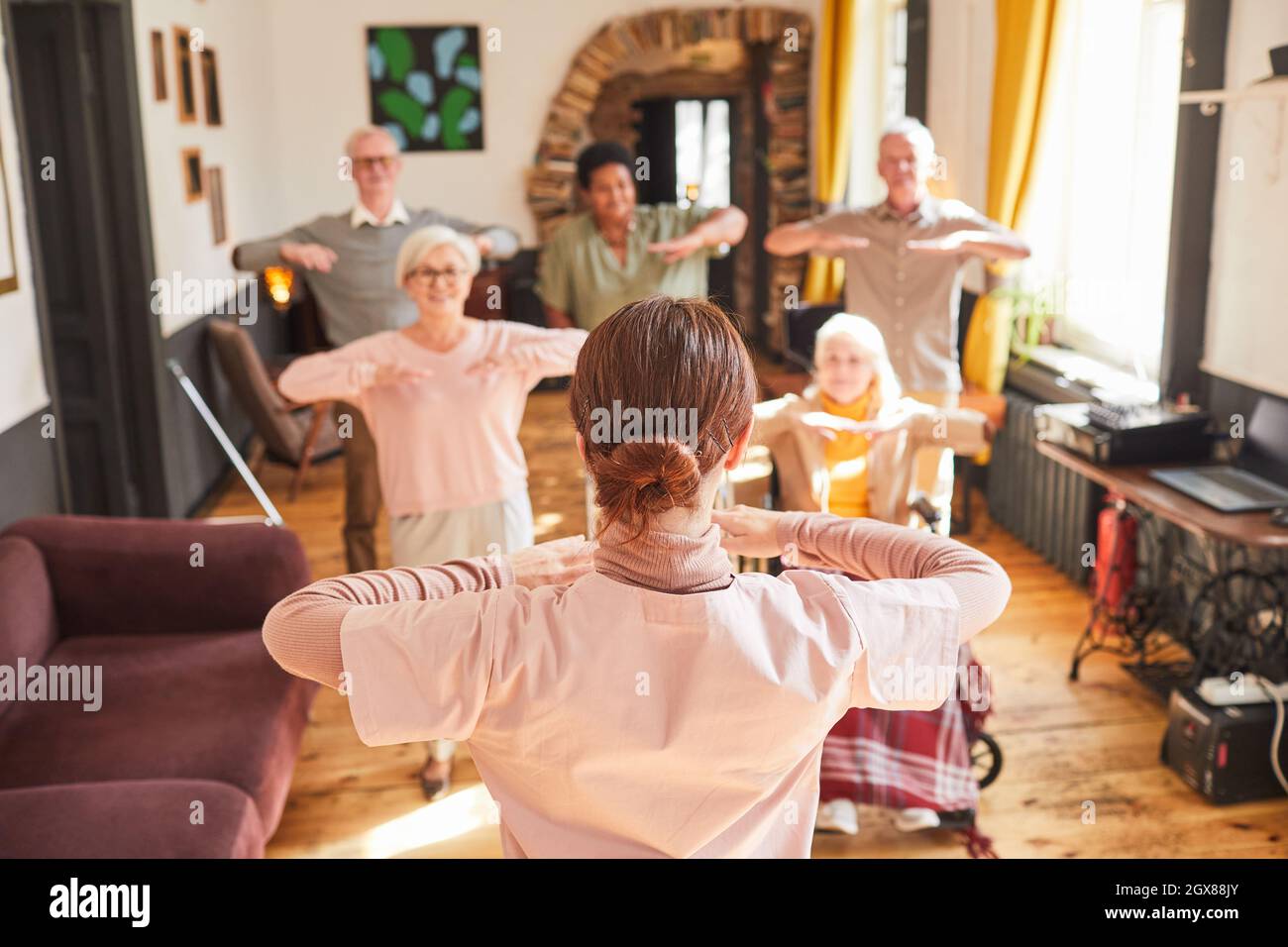Back view at young woman coordinating group of senior people during ...
