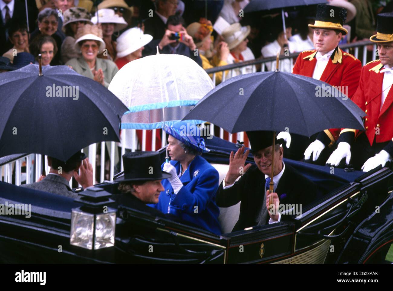 The Queen and the Duke of Edinburgh cover up against the rain, as they ...