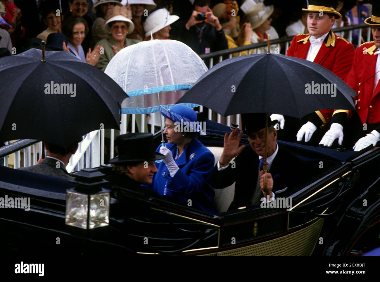 The Queen and the Duke of Edinburgh cover up against the rain, as they ...