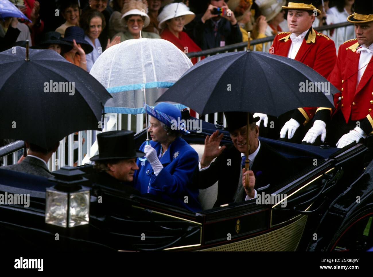 The Queen and the Duke of Edinburgh cover up against the rain, as they ...