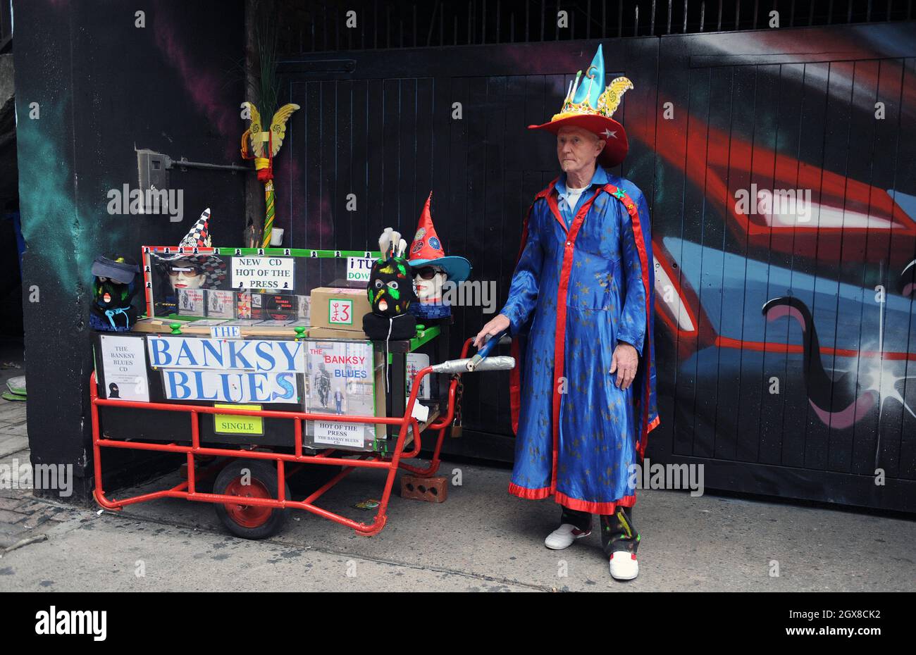 A street vendor in costume sells sells 'Banksy Blues' wares at the See ...