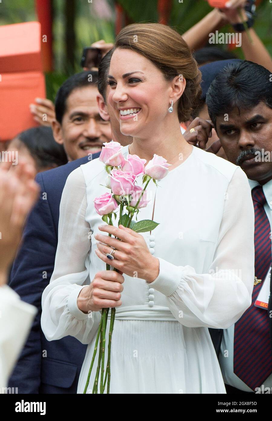 Catherine, Duchess of Cambridge smiles as she receives a bunch of roses ...
