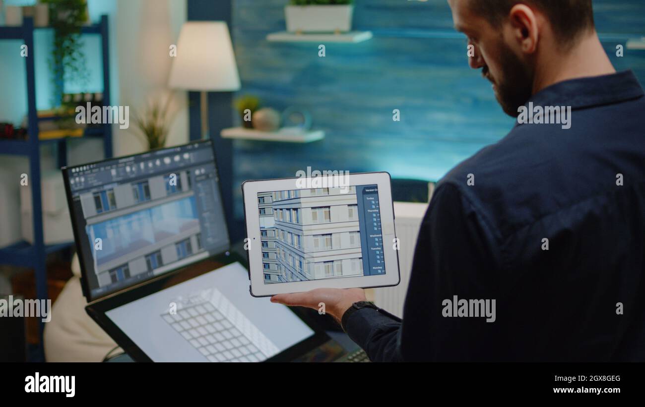 Architect holding digital tablet with building model for construction ...