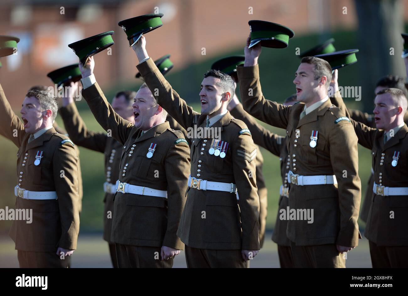 Soldiers from 1st Battalion Irish Guards raise their caps after ...