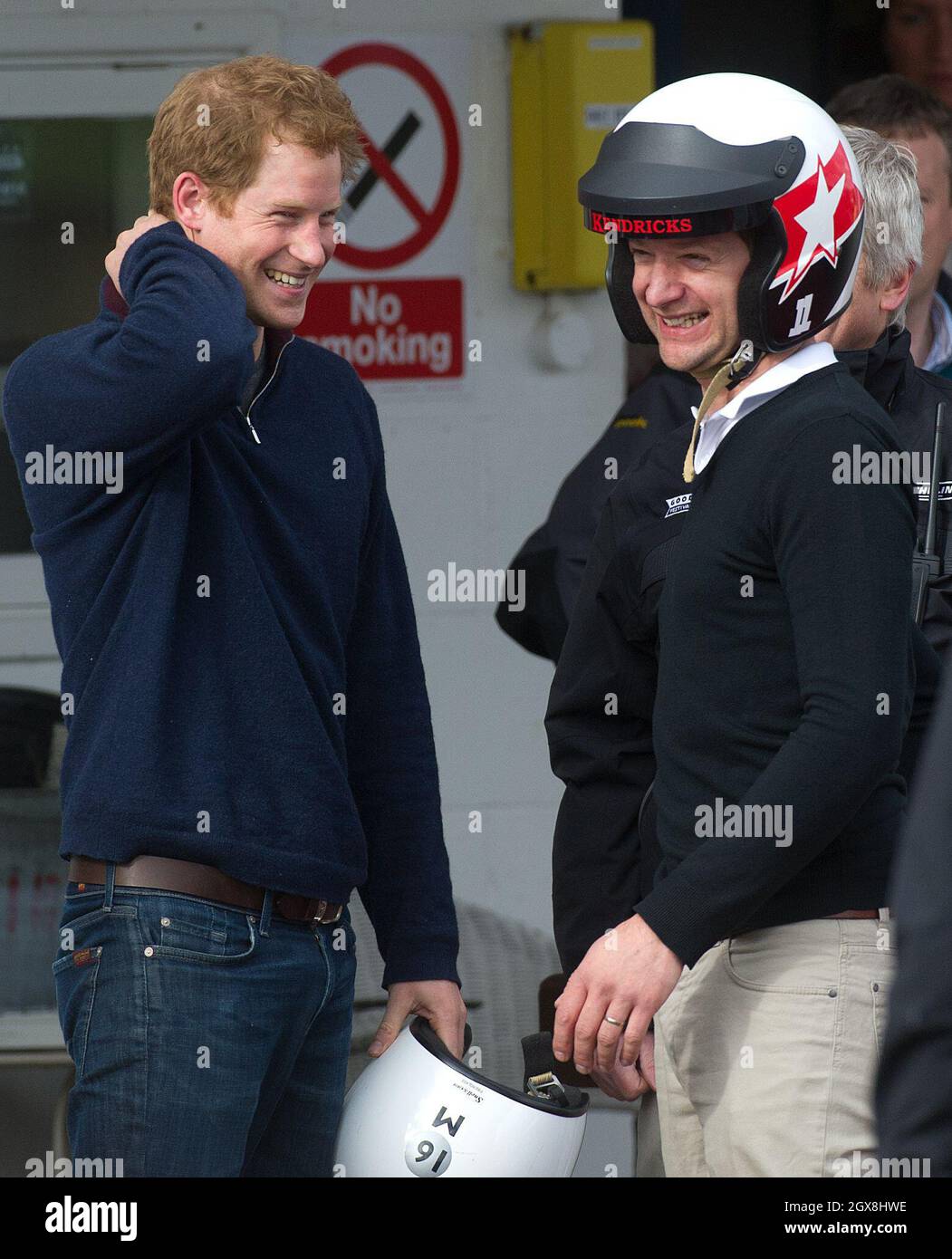Prince Harry jokest as he prepares to drive cars around the track ...