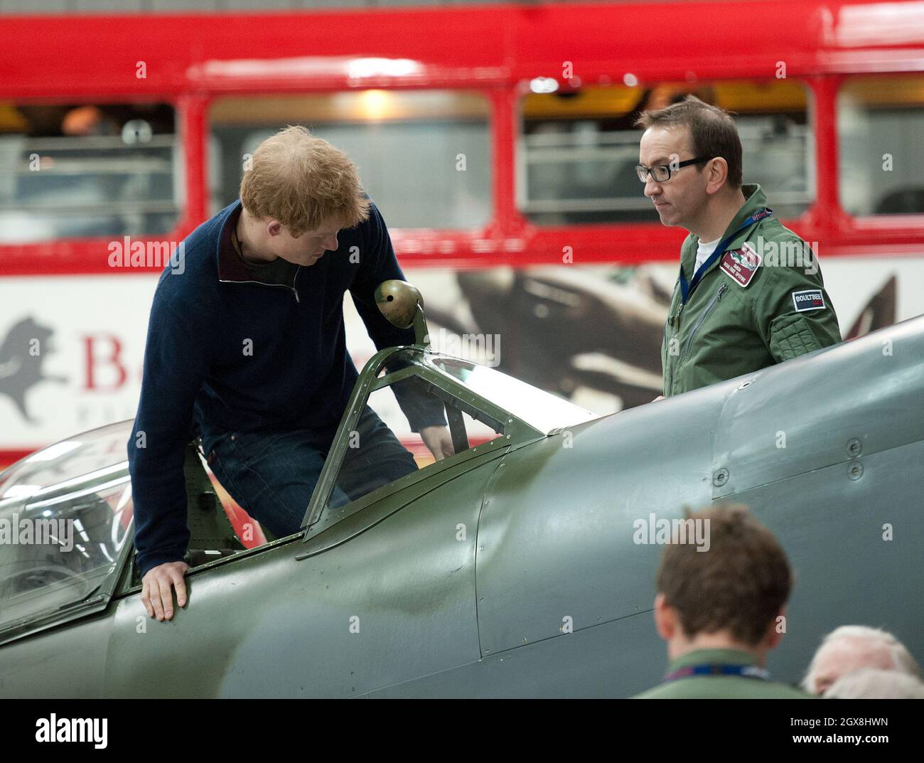 Prince Harry climbs into the cockpit of an aircraft inside a hanger at ...