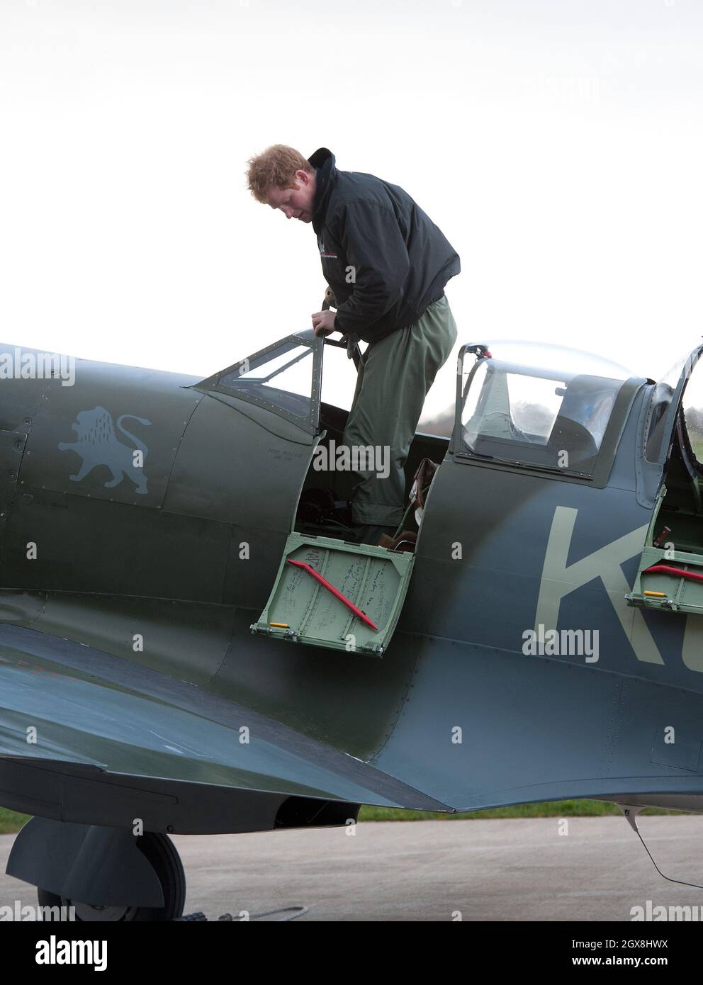 Prince Harry climbs into the cockpit of a Spitfire aircraft at the ...