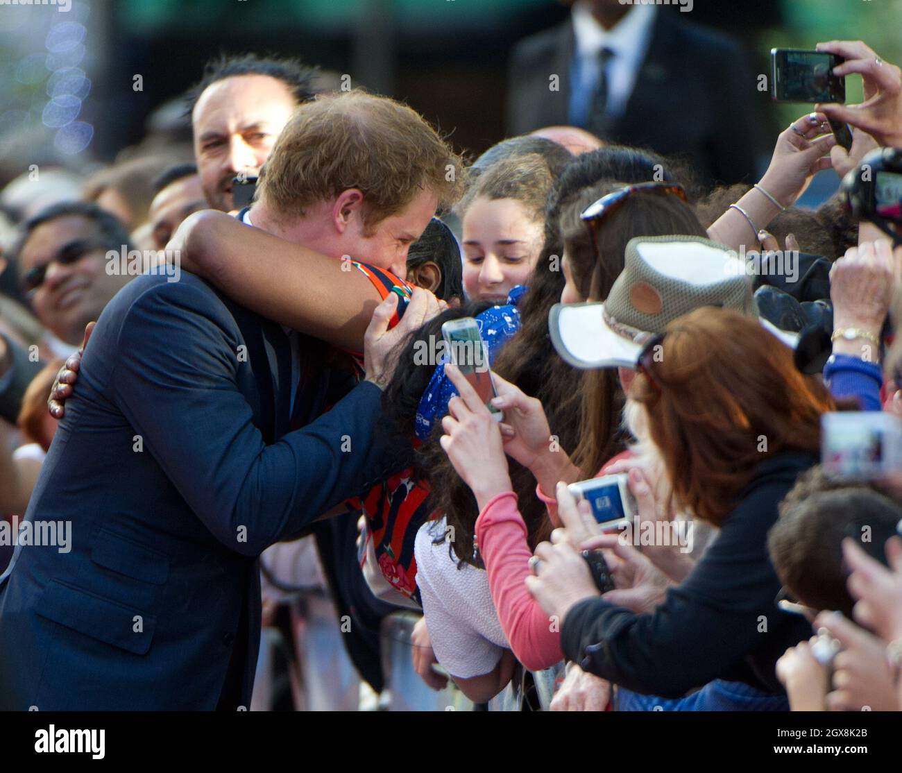 Prince Harry receives a hug from a well-wisher as he arrives for a 50th ...