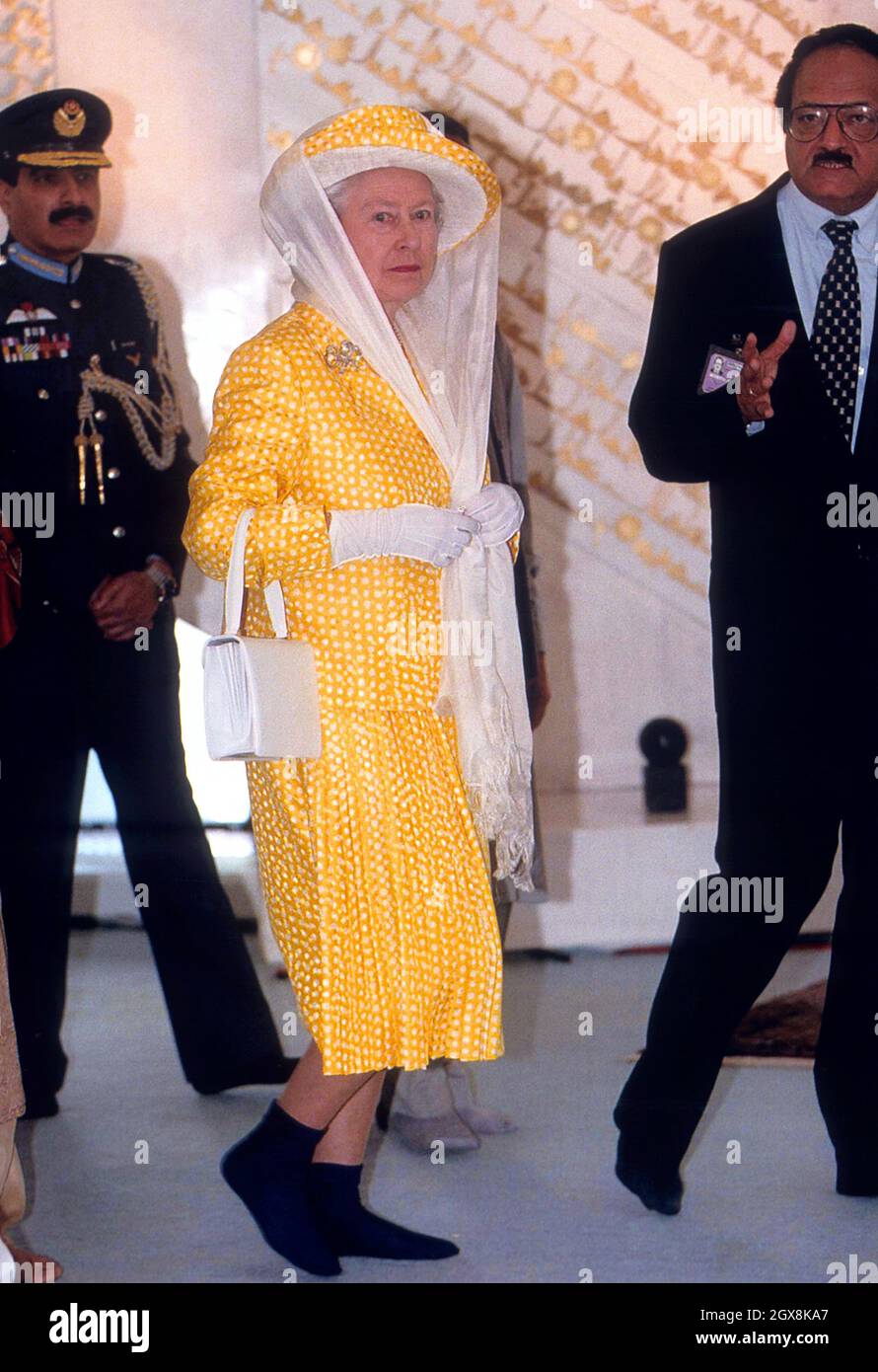 Queen Elizabeth II wearing socks and headscarf, tours the Shah Faisal ...