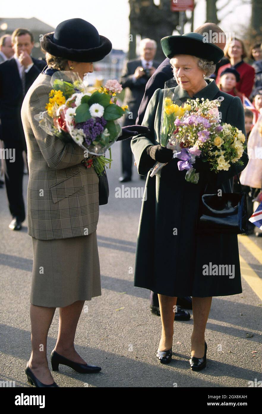 Queen Elizabeth II receives flowers during her visit to Royal Surrey ...