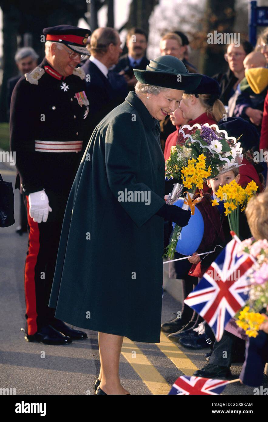 Queen Elizabeth II receives flowers during her visit to Royal Surrey ...