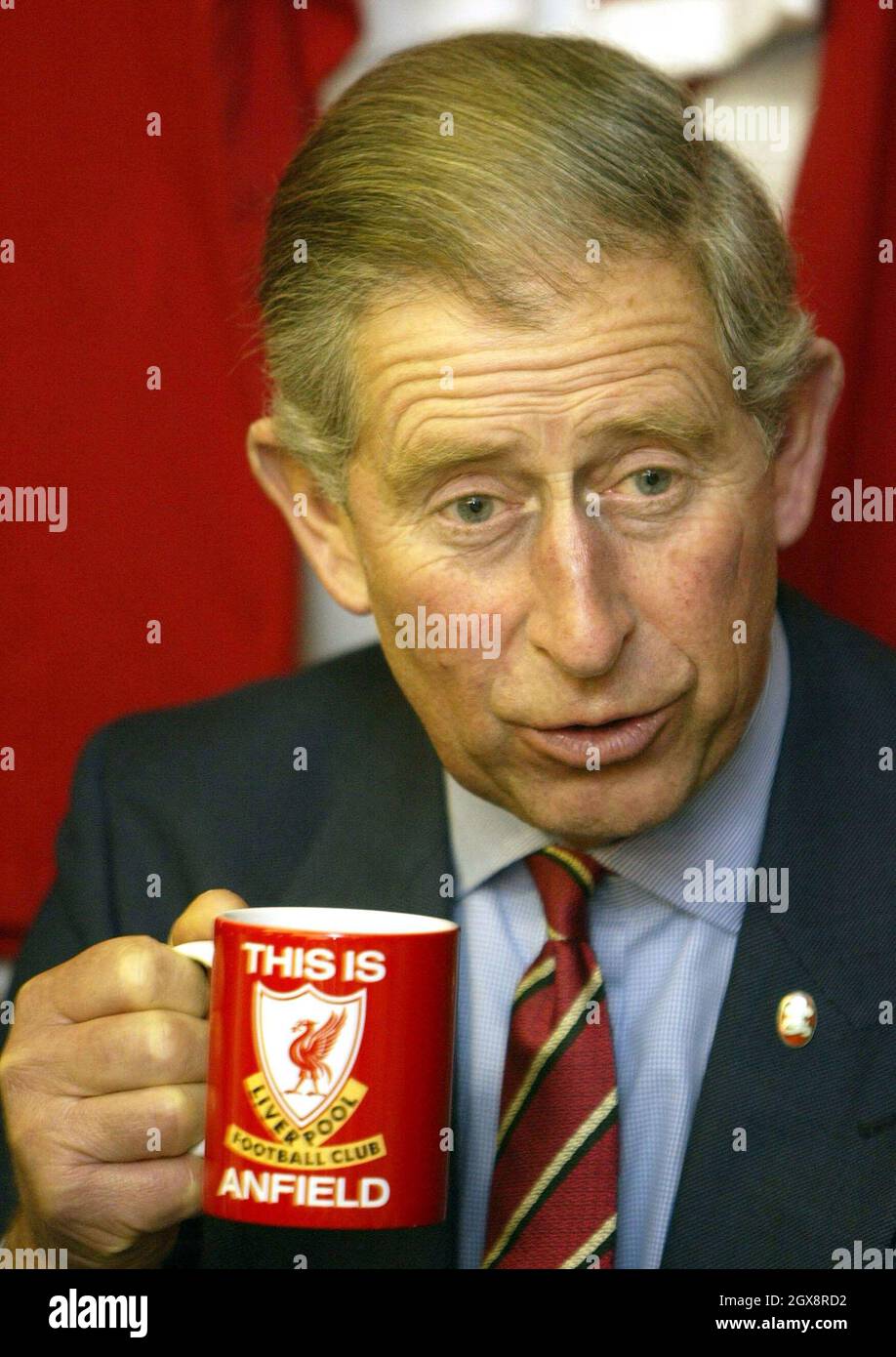 Charles, Prince of Wales sips tea from a Liverpool Football club mug ...