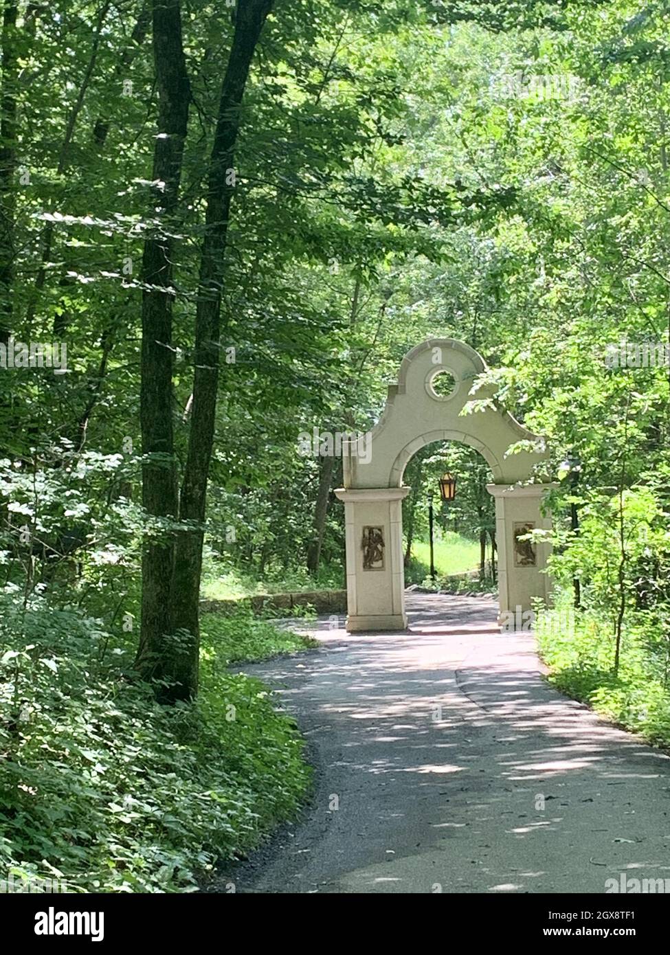 Walkway in a park through an arch structure Stock Photo - Alamy