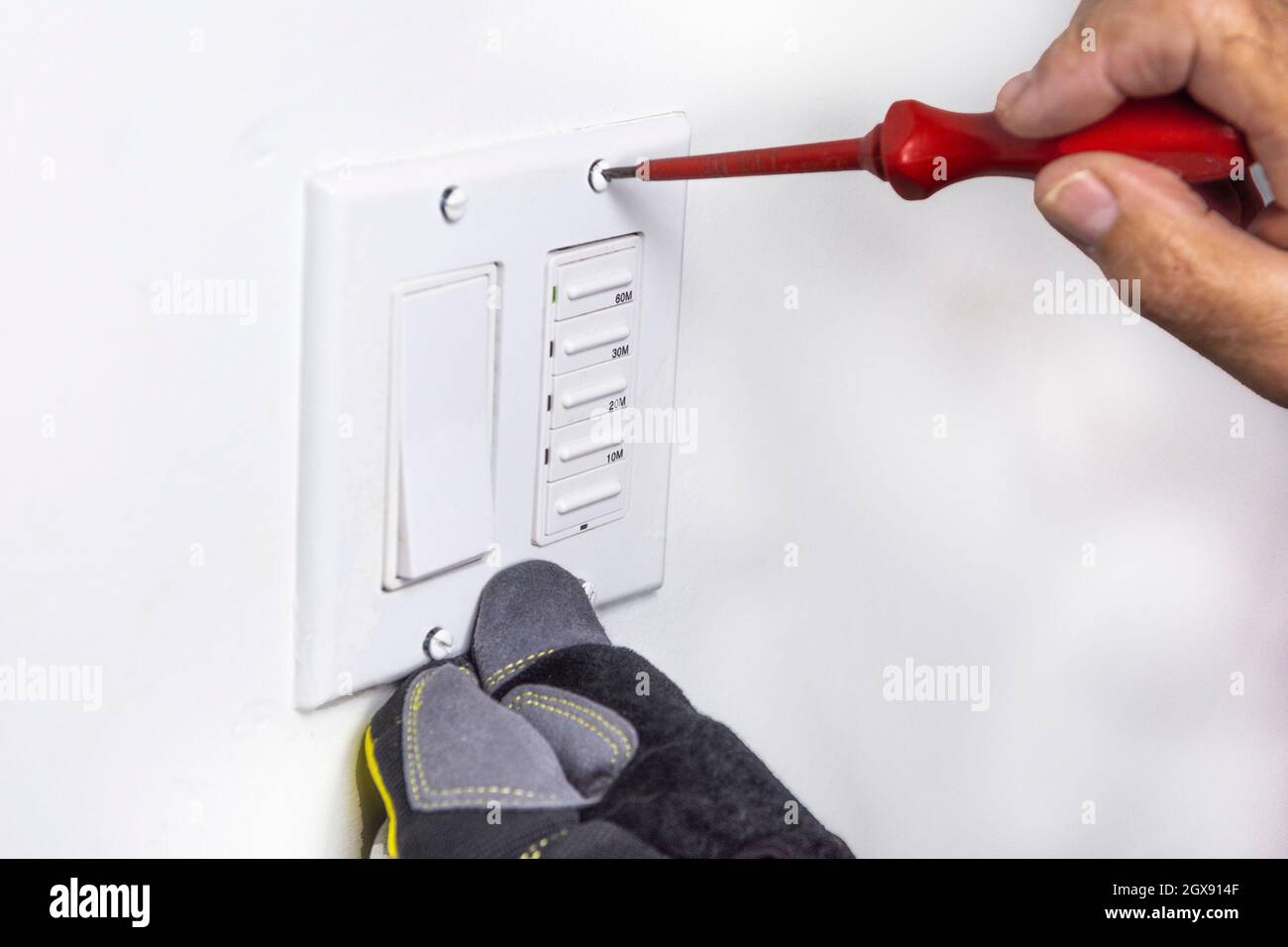 The electrician prepared the screws for securing the switch cover and ...