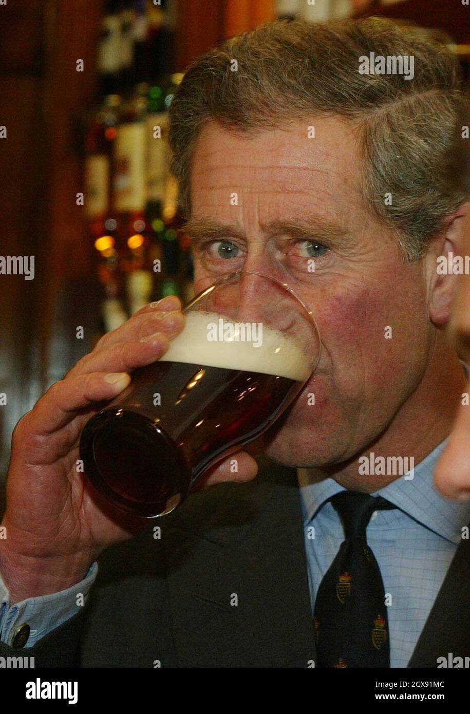 Prince Charles samples a pint of beer during his visit to the village ...