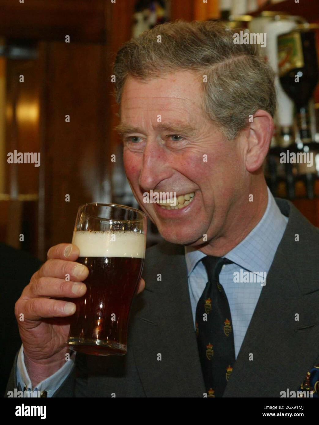 Prince Charles samples a pint of beer during his visit to the village ...