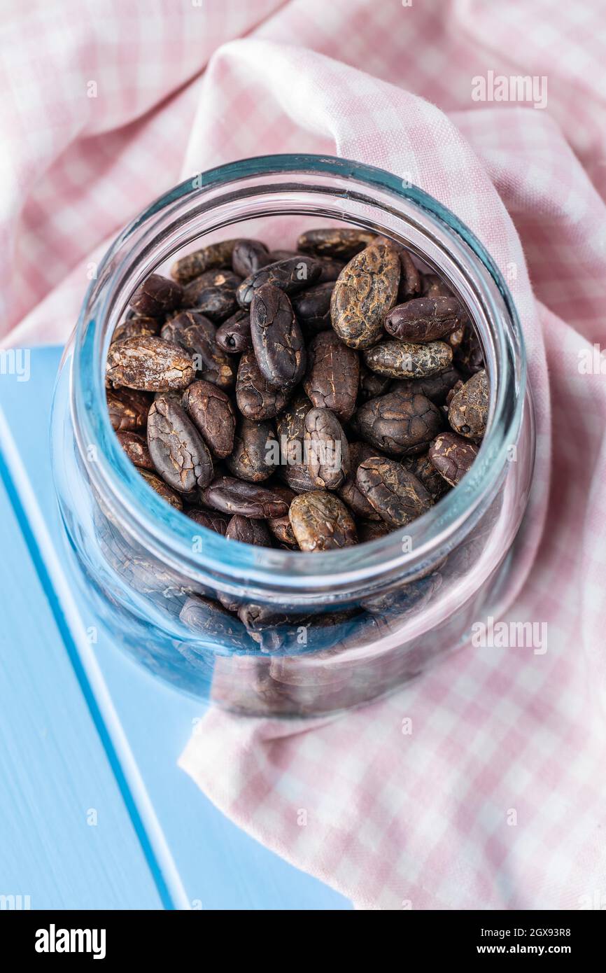 Roasted cocoa beans in jar on blue table Stock Photo - Alamy