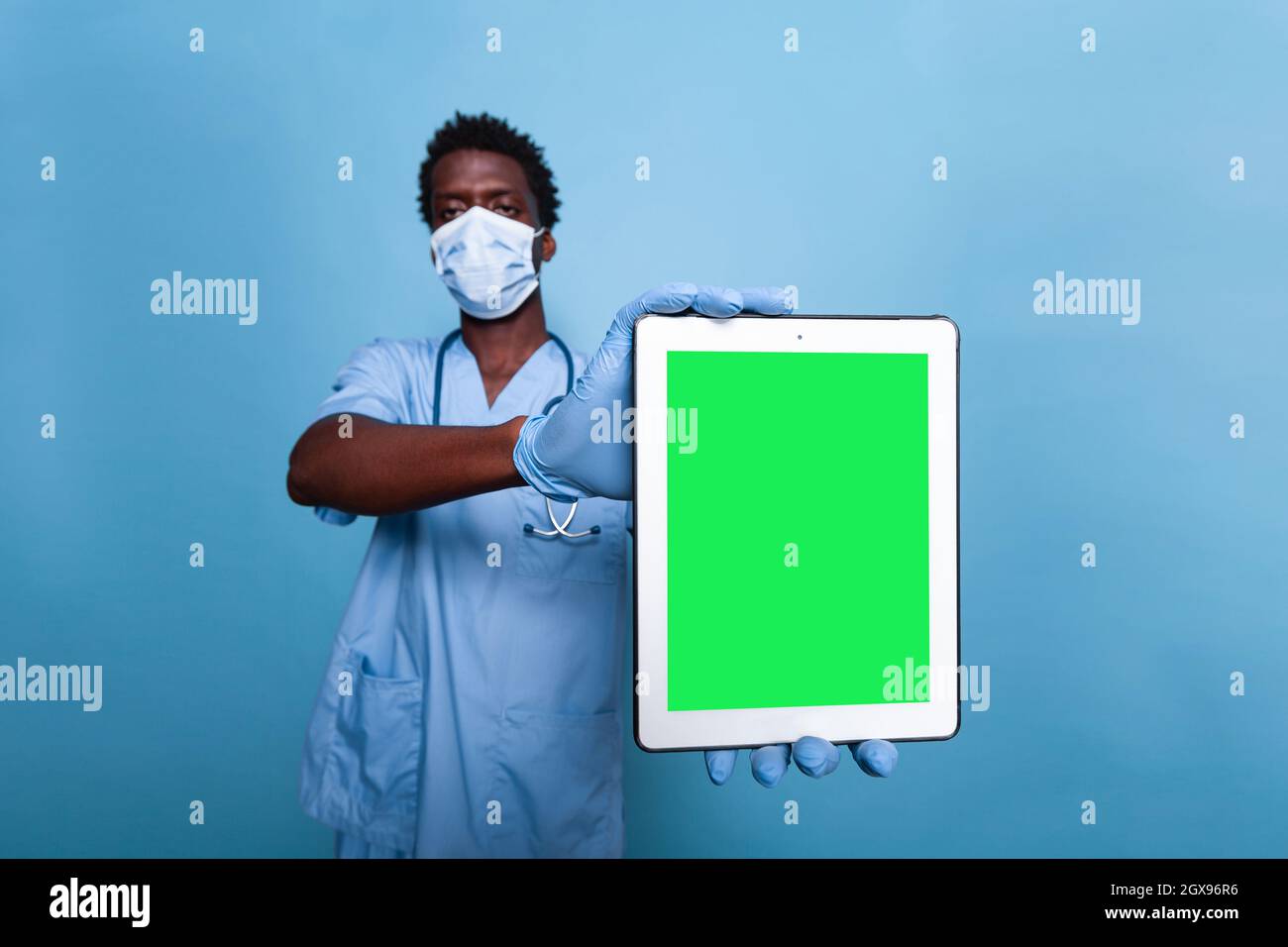Medical nurse holding vertical green screen on tablet in studio ...
