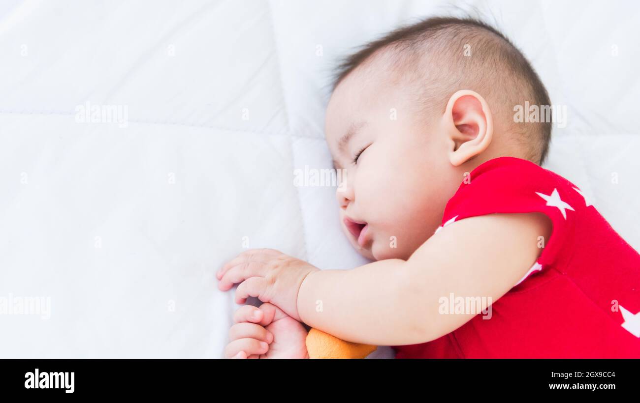 Portrait of beautiful Asian newborn little baby sleeping on white bed ...