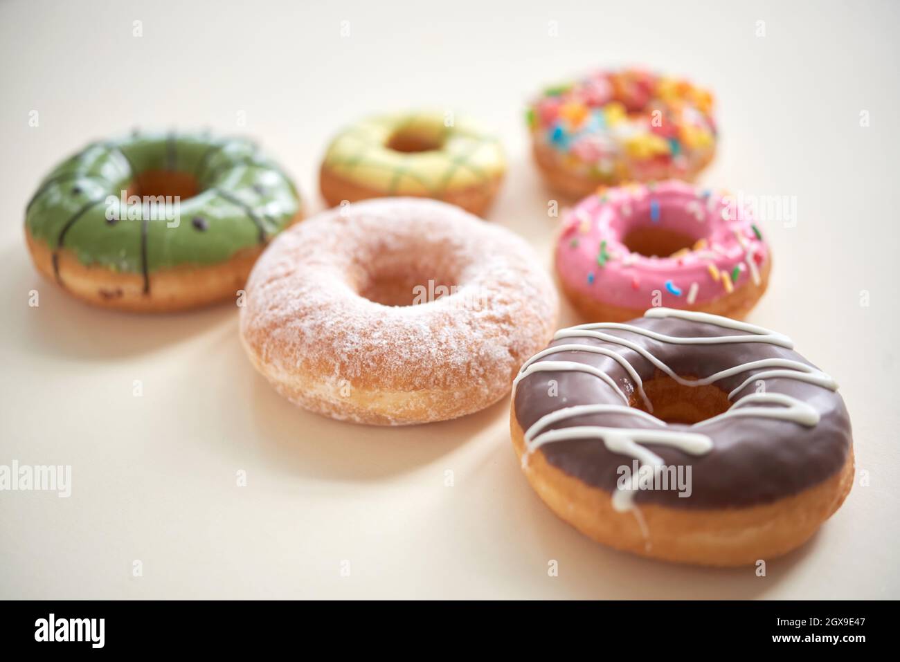 Close-up of various glazed donuts placed in shape of triangle on table ...