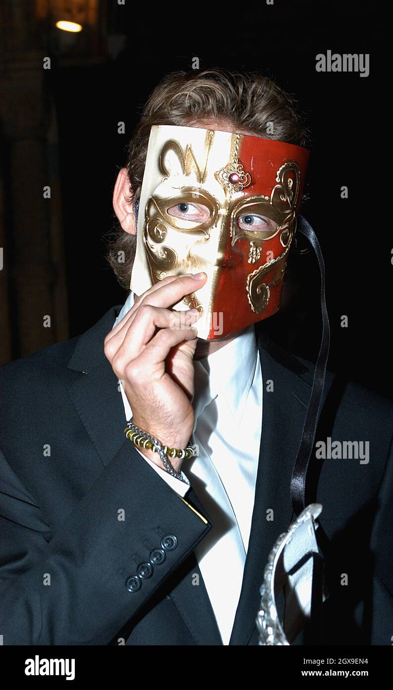 Jenson Button hides behind a mask at the Barnardos Black Cat Ball held ...