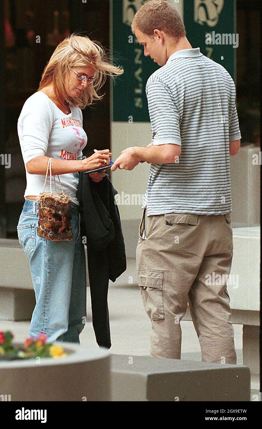 Rachel Hunter signs an autograph for a fan as she goes shopping with a ...