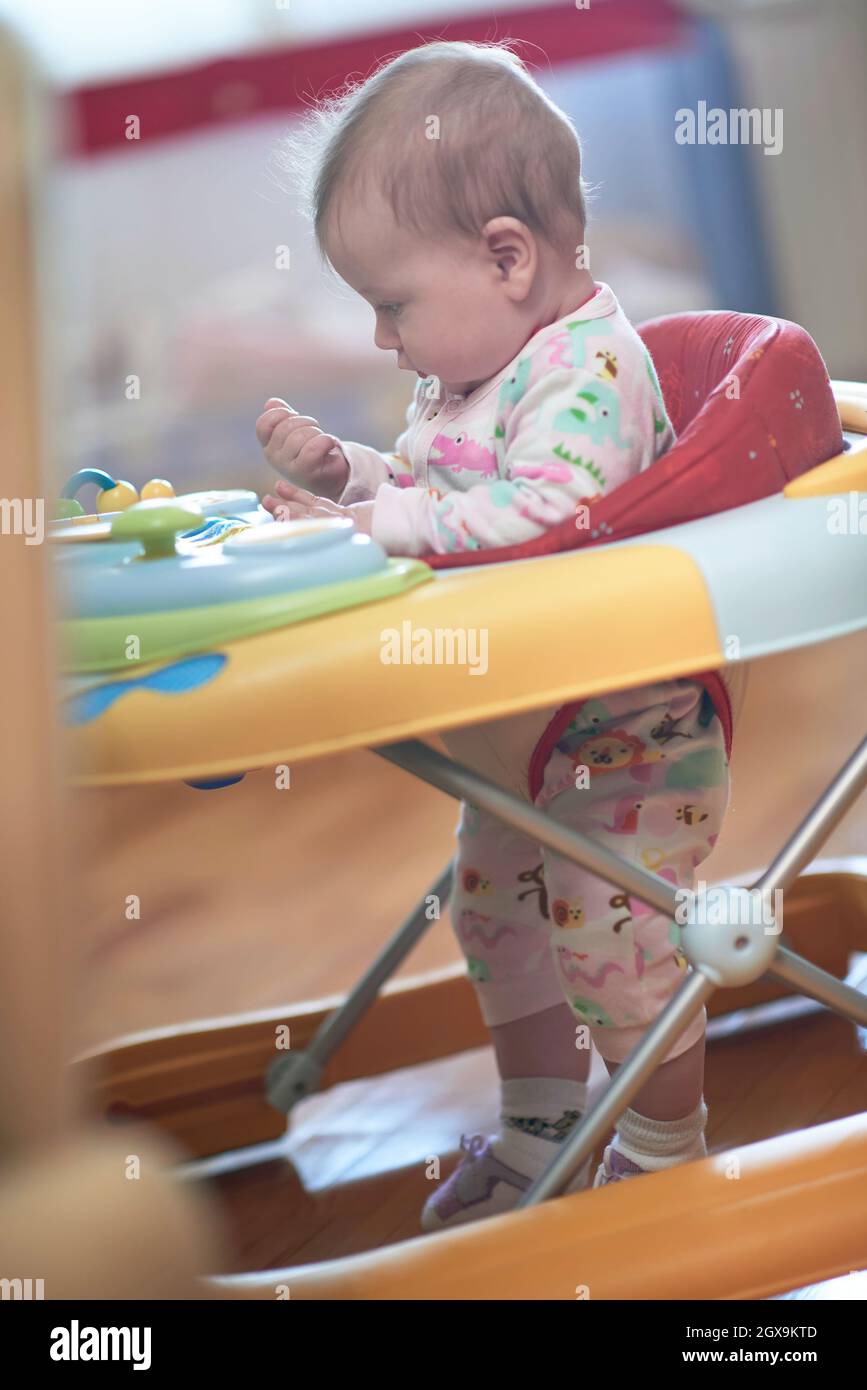 cute little baby learning to walk in walker at home Stock Photo - Alamy