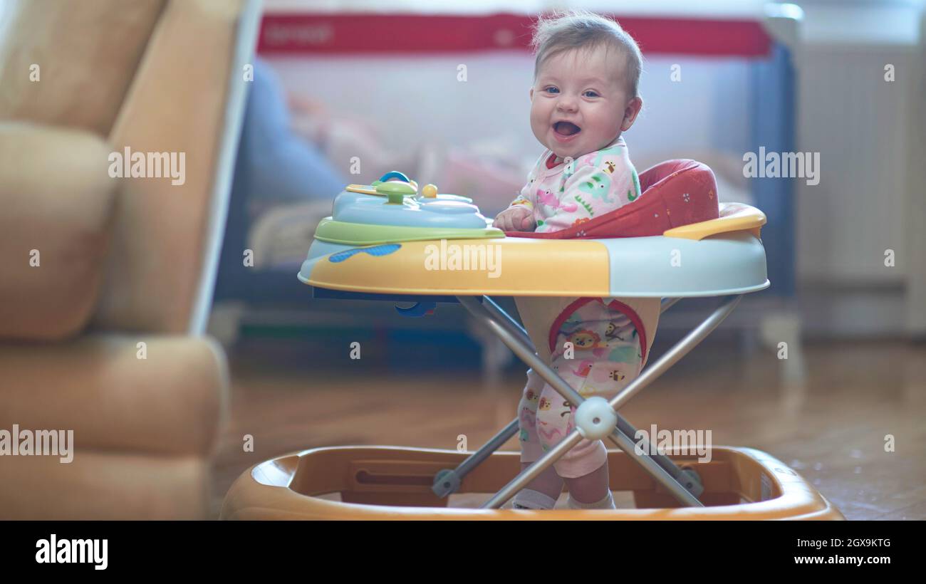 cute little baby learning to walk in walker at home Stock Photo - Alamy