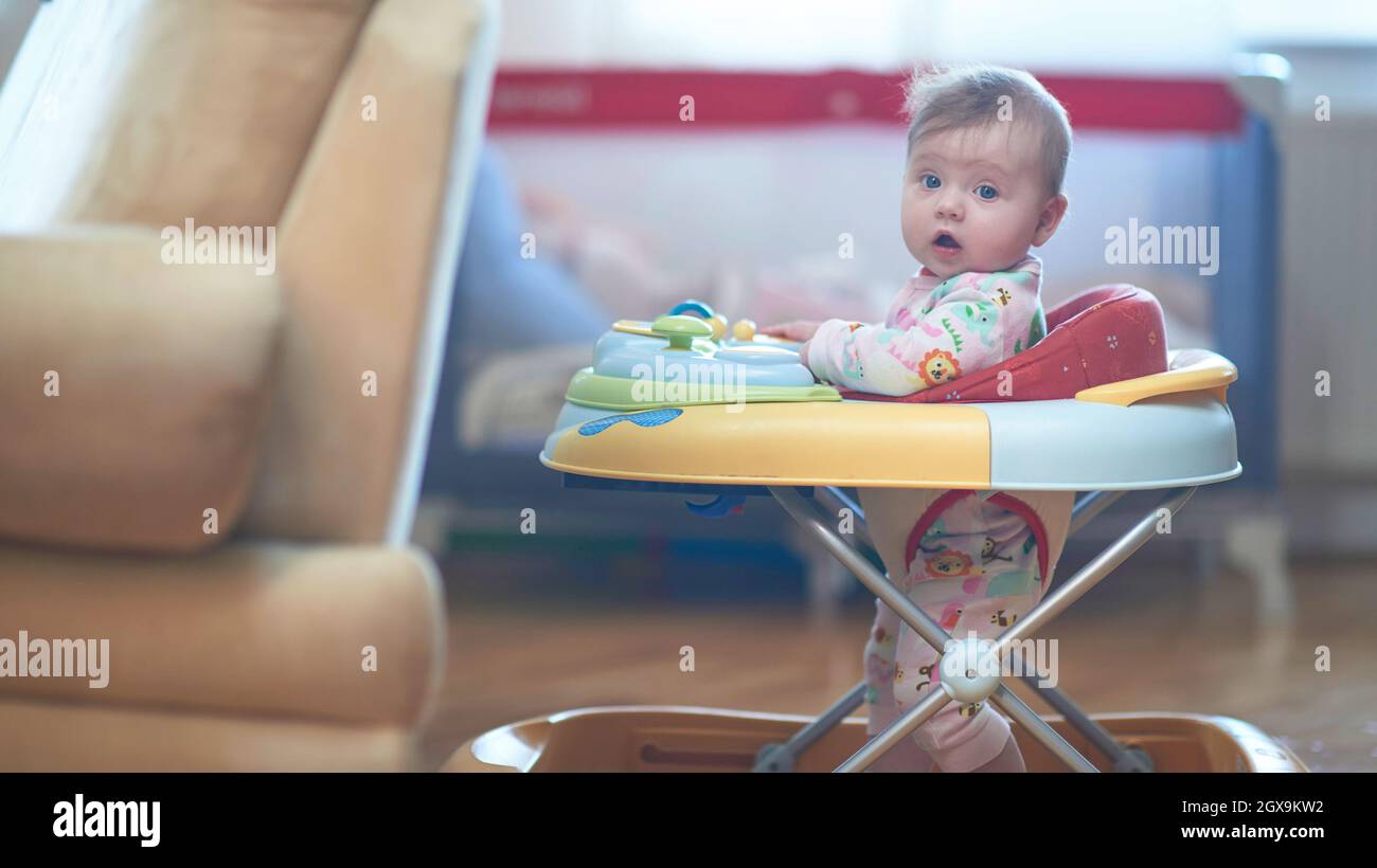 cute little baby learning to walk in walker at home Stock Photo - Alamy