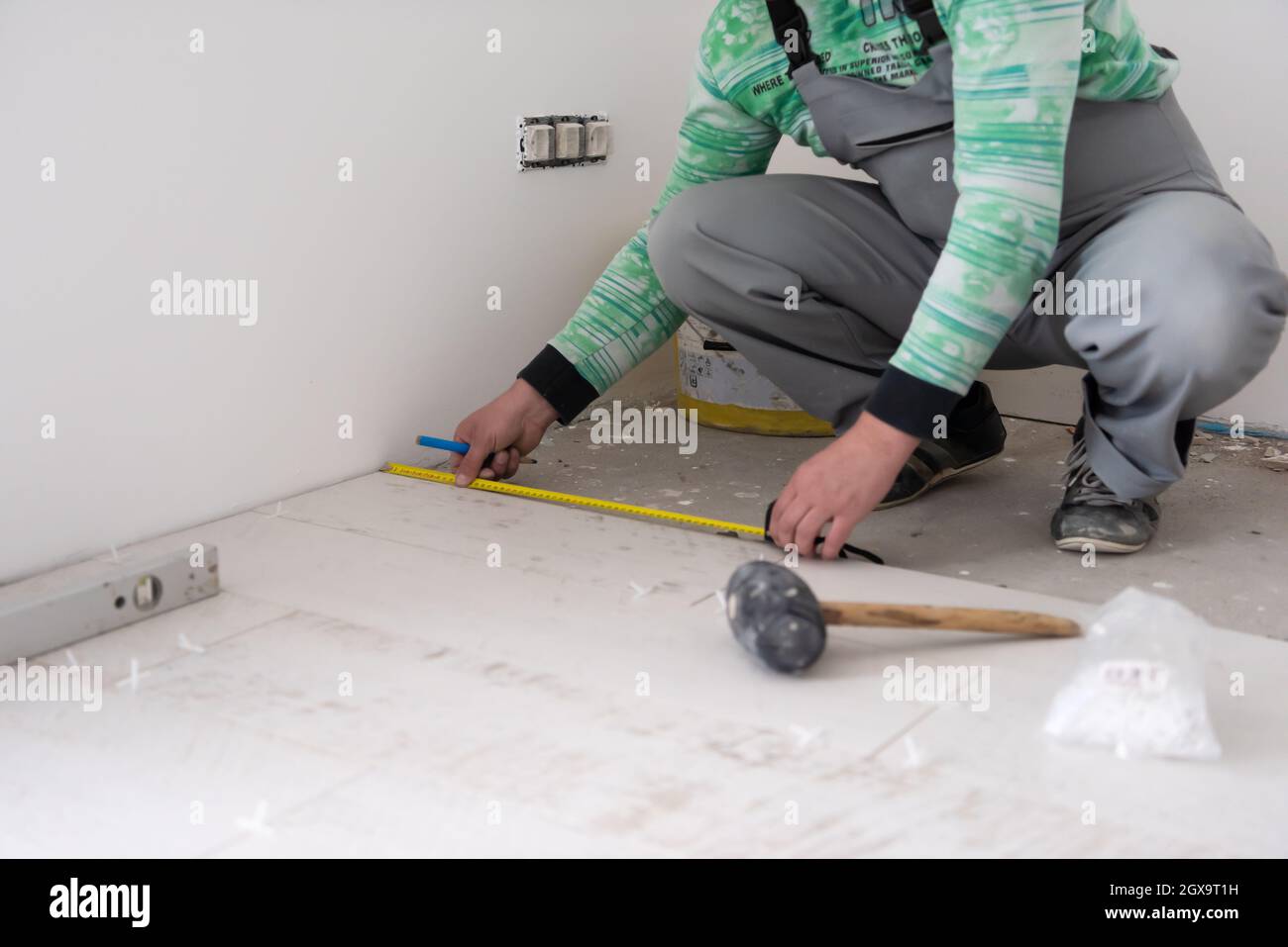 skilled worker installing the ceramic wood effect tiles on the floor ...