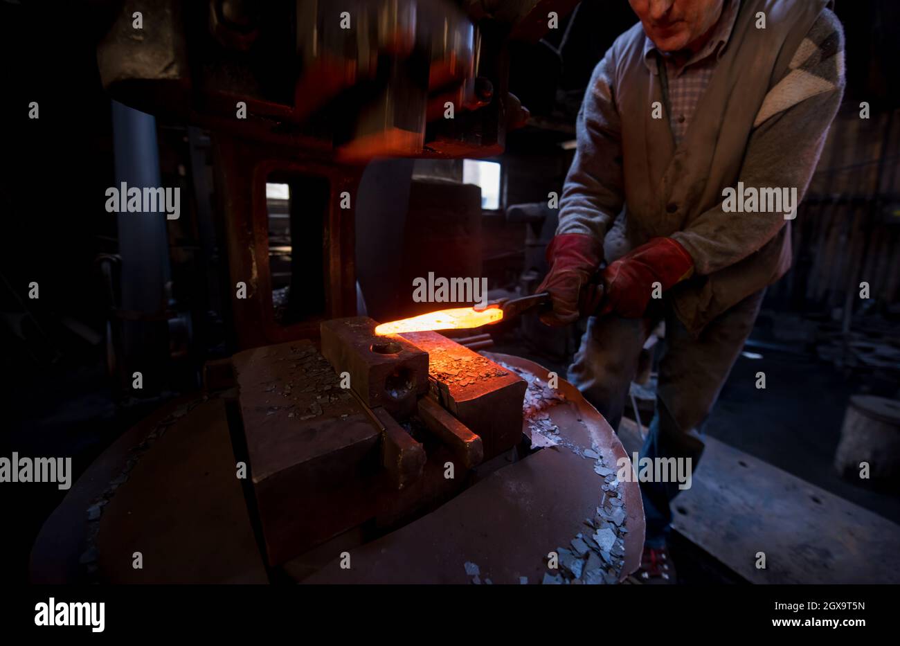 blacksmith manually forging the red hot molten metal on the anvil in ...