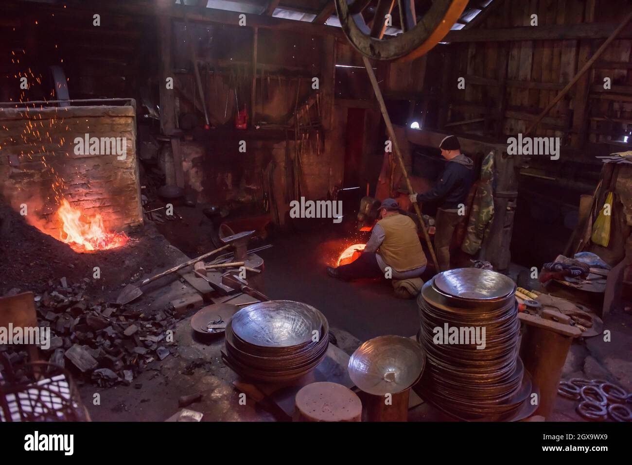 two real brutal traditional blacksmith workers working together with a ...