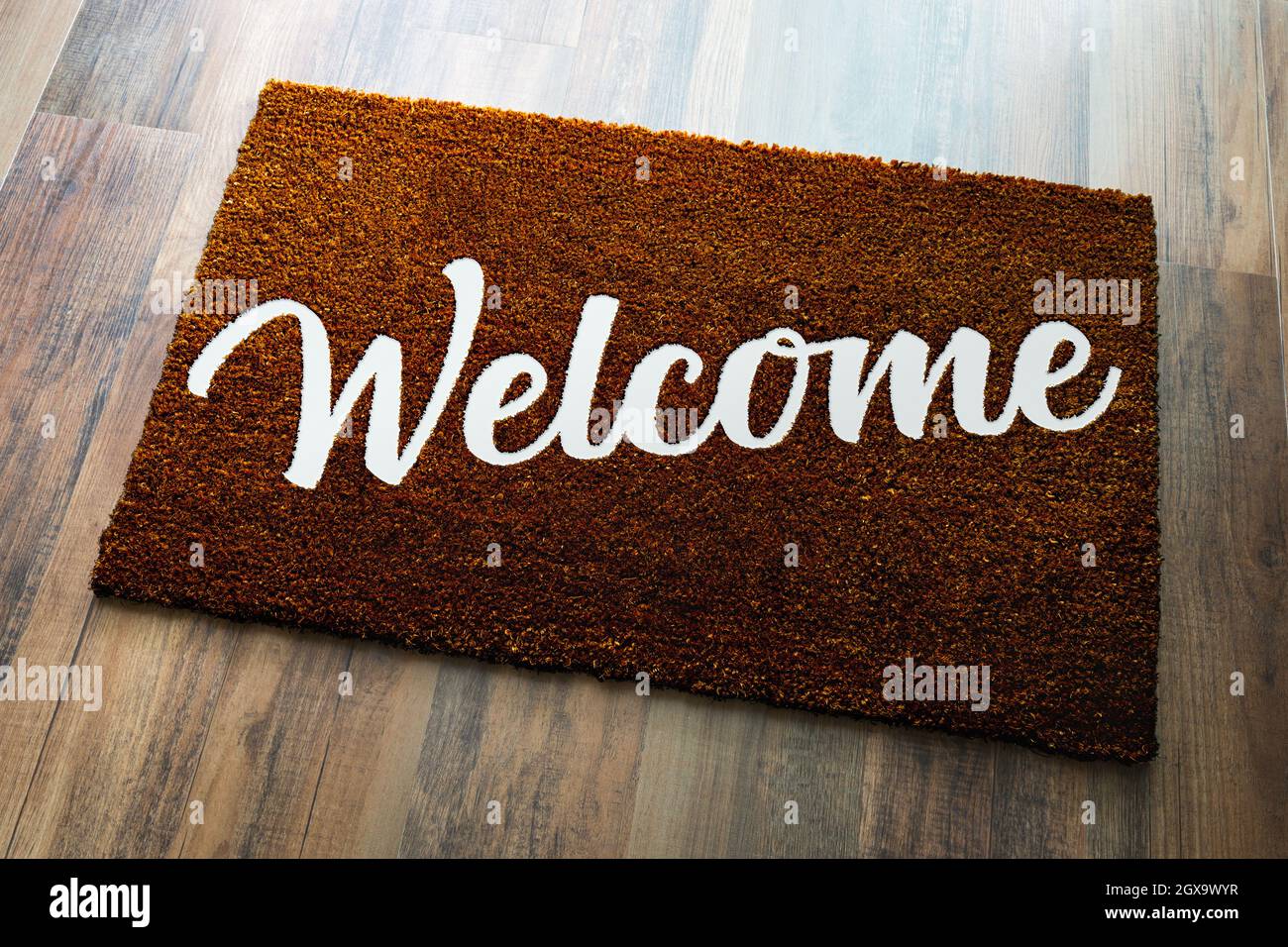 Dark Brown Welcome Mat On Wood Floor Background Stock Photo - Alamy
