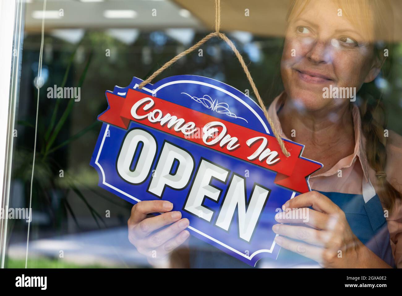Happy Female Store Owner Turning Open Sign in Window Stock Photo - Alamy