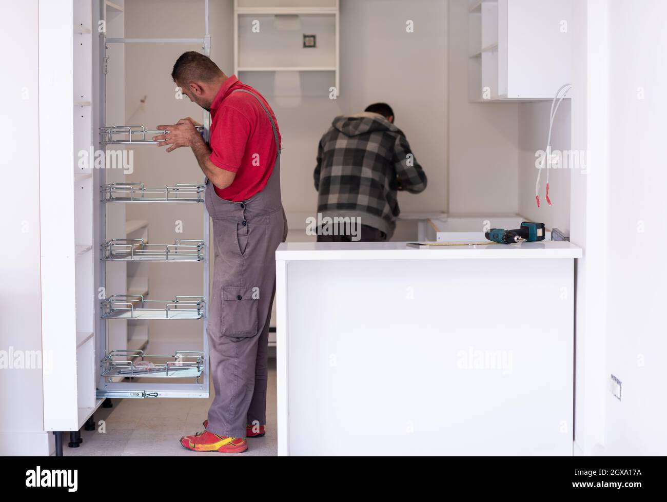 two professional workers installing a new stylish modern kitchen ...